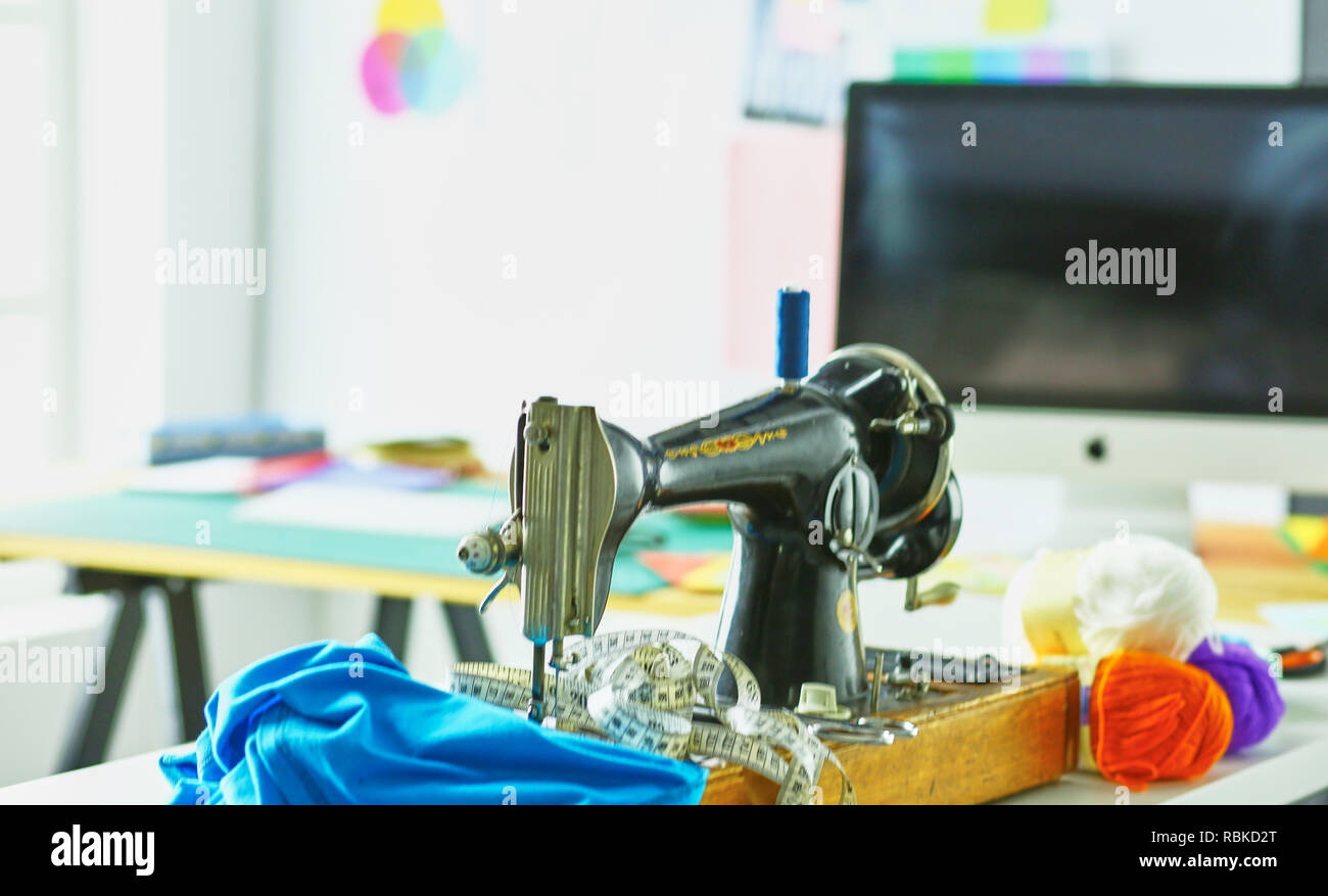 Retro sewing machine on designer clothes desktop Stock Photo - Alamy