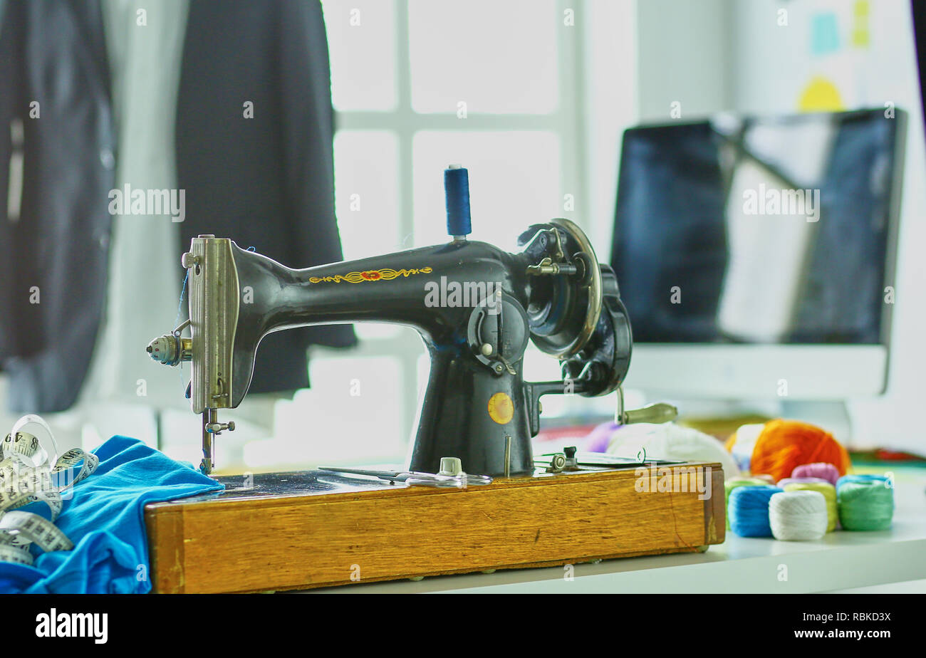 Retro sewing machine on designer clothes desktop Stock Photo - Alamy