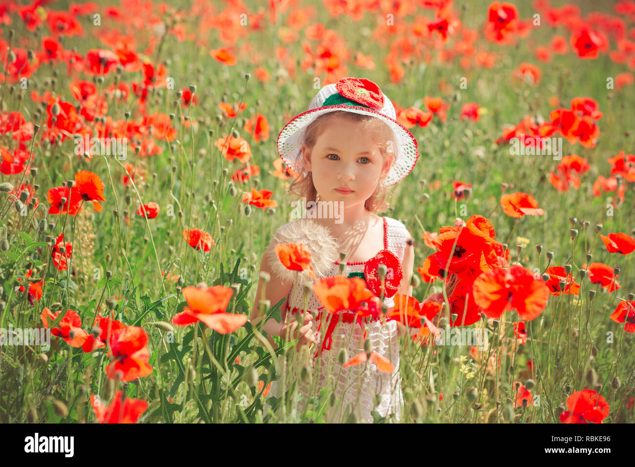 Cute blond young girl child stylish dressed in white handmade hooked ...