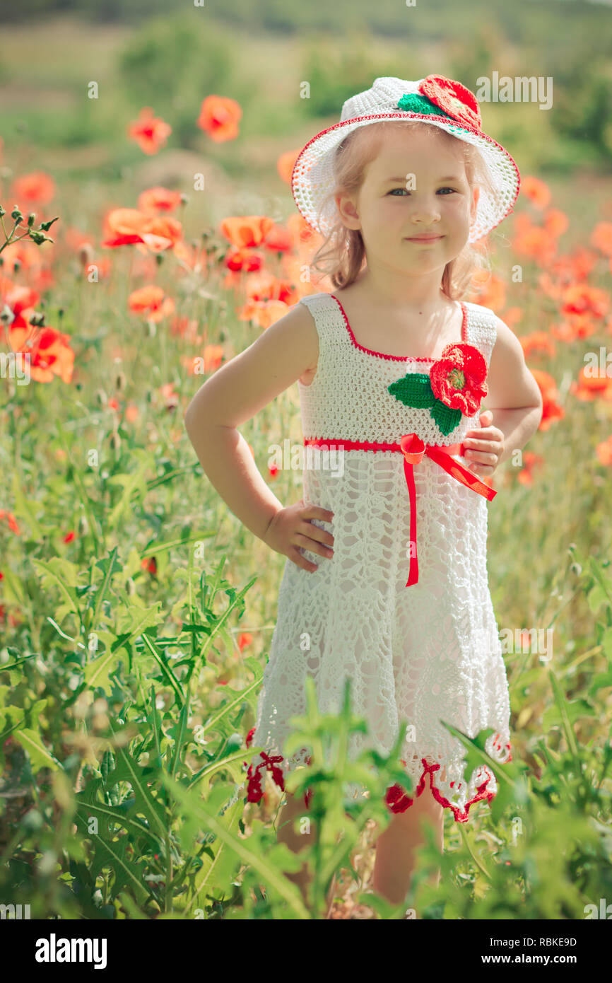 Cute blond young girl child stylish dressed in white handmade hooked ...