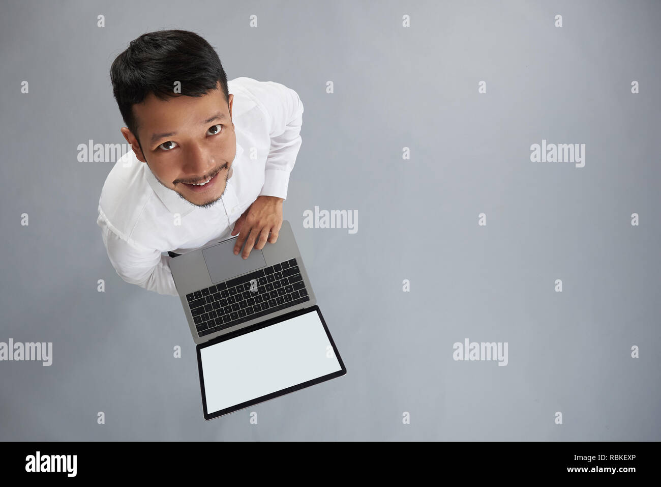 Young asian man working on laptop above top view on gray studio ...
