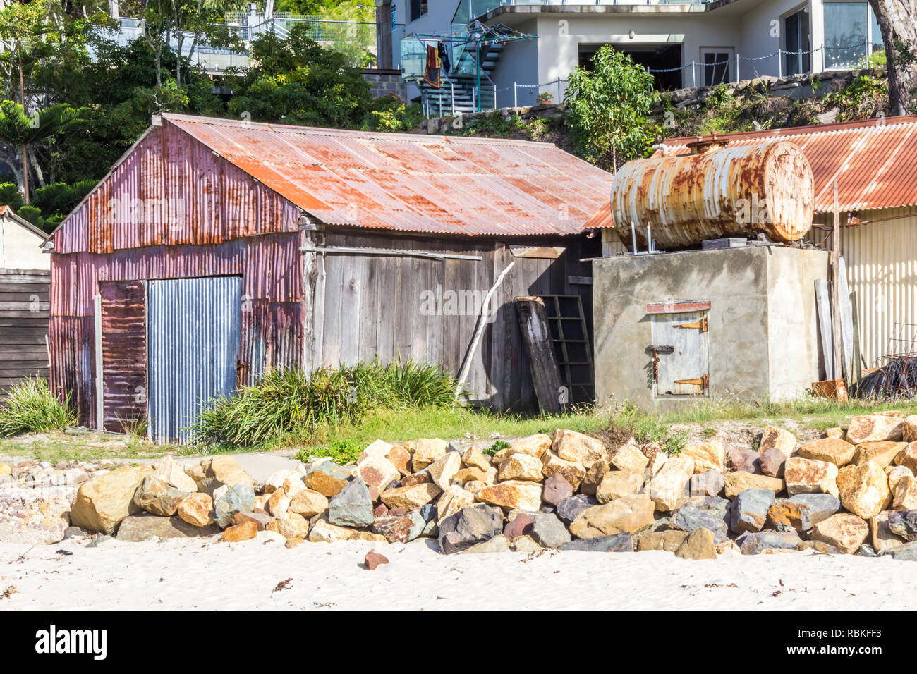 Corrugated hut with oil storage drum, beach by Pambula river estuary ...