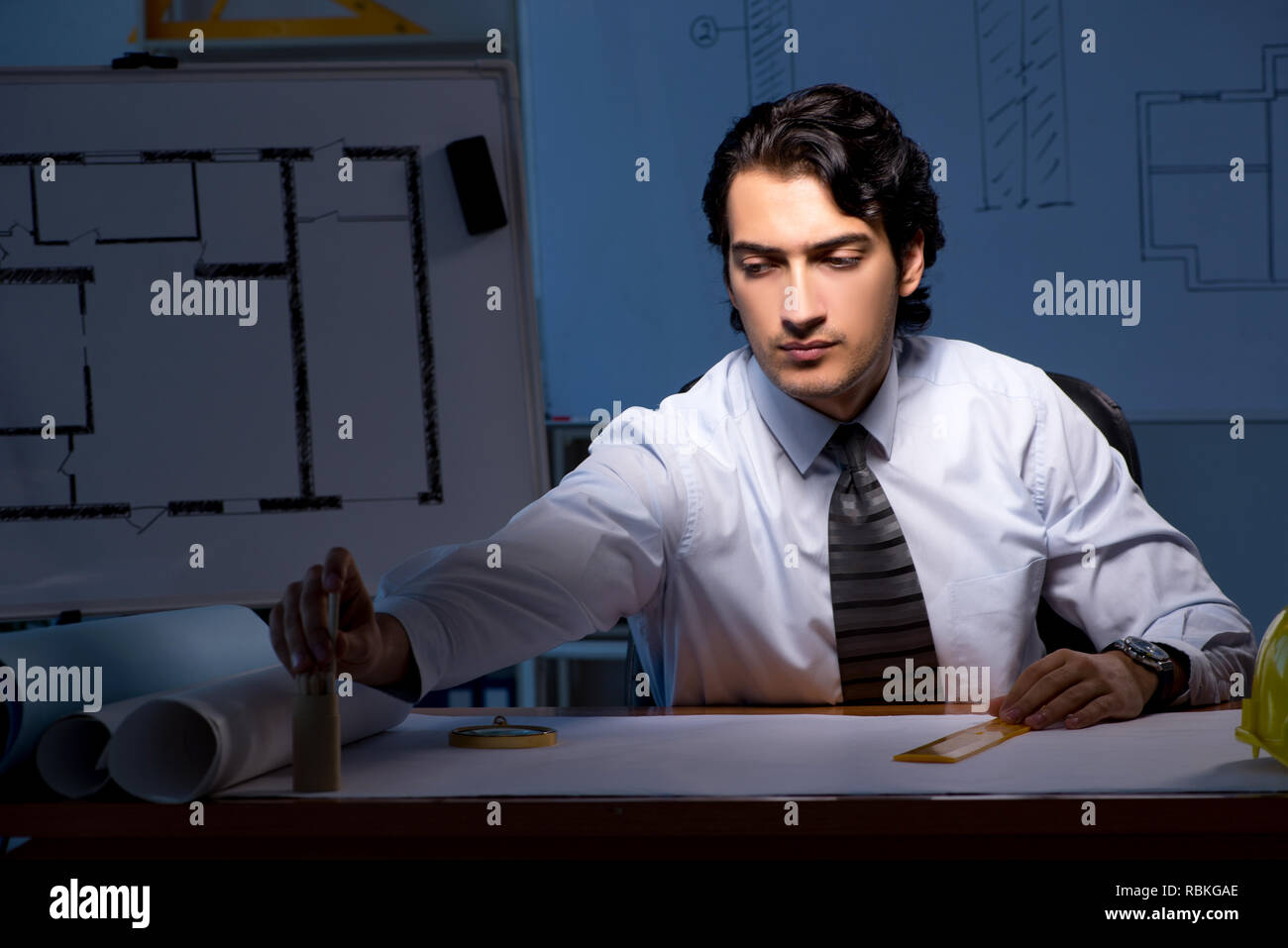 Young construction architect working on project at night Stock Photo ...