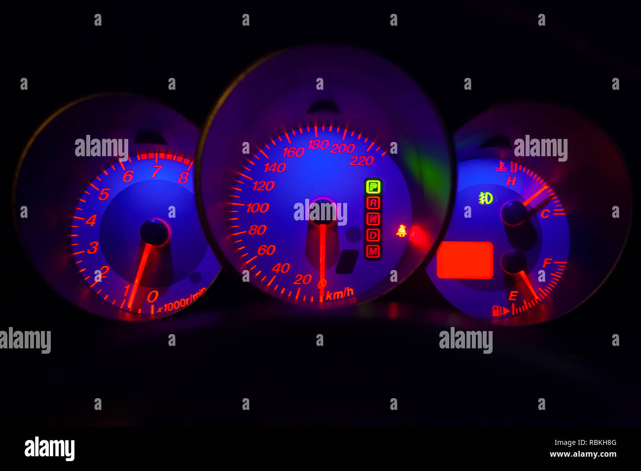 The dashboard of the car is glowing blue and red at night with a ...