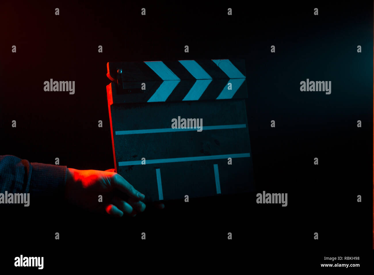 Closed clapperboard for cinema in hand, before filming on a black ...