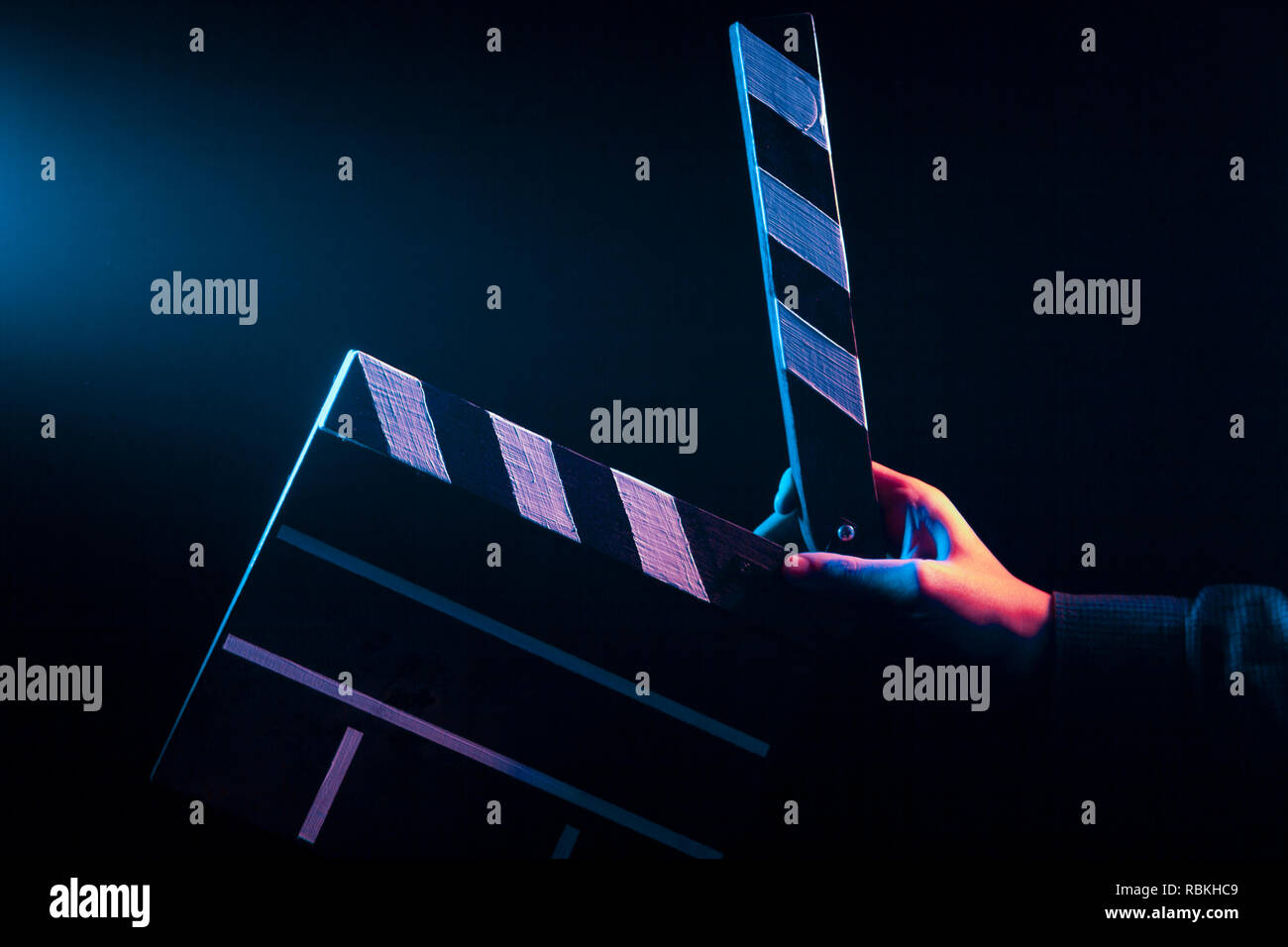 Opened clapperboard for cinema in hand, before filming on a black ...