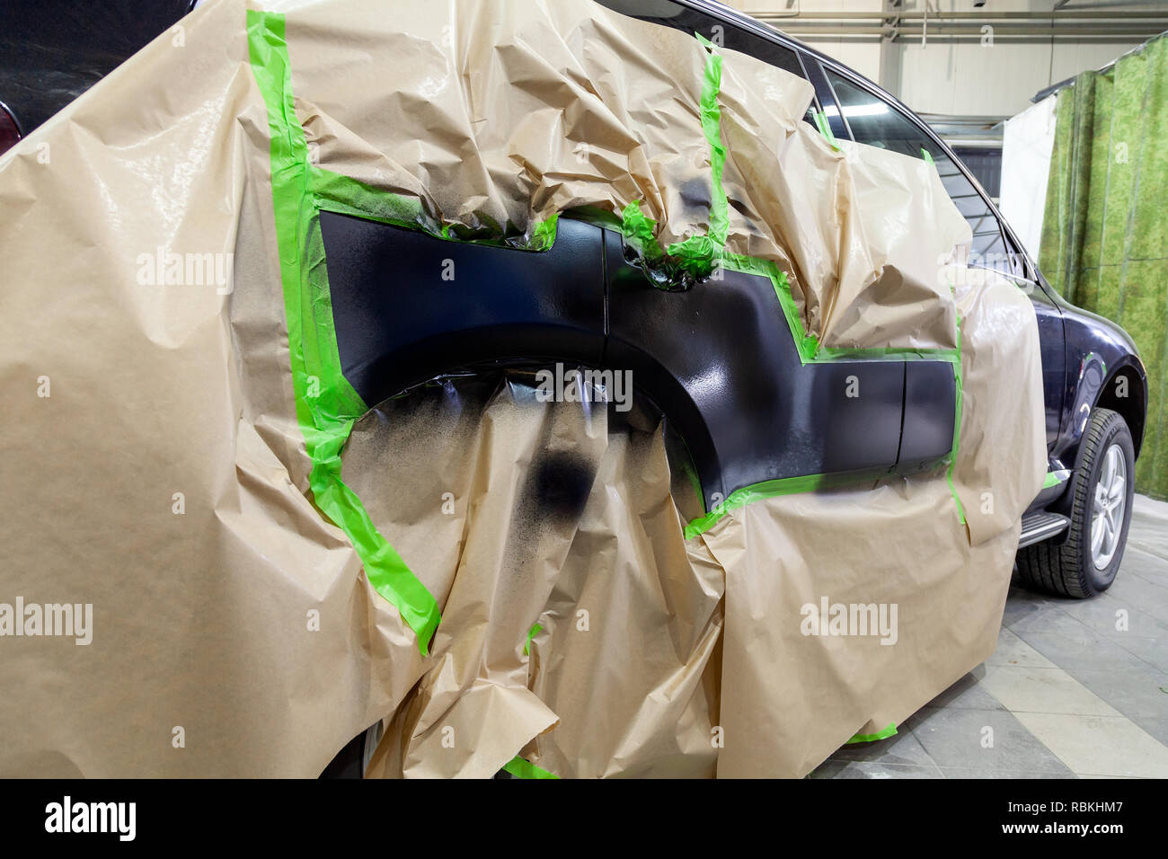 Partial painting of the side elements of the body of a black SUV car ...