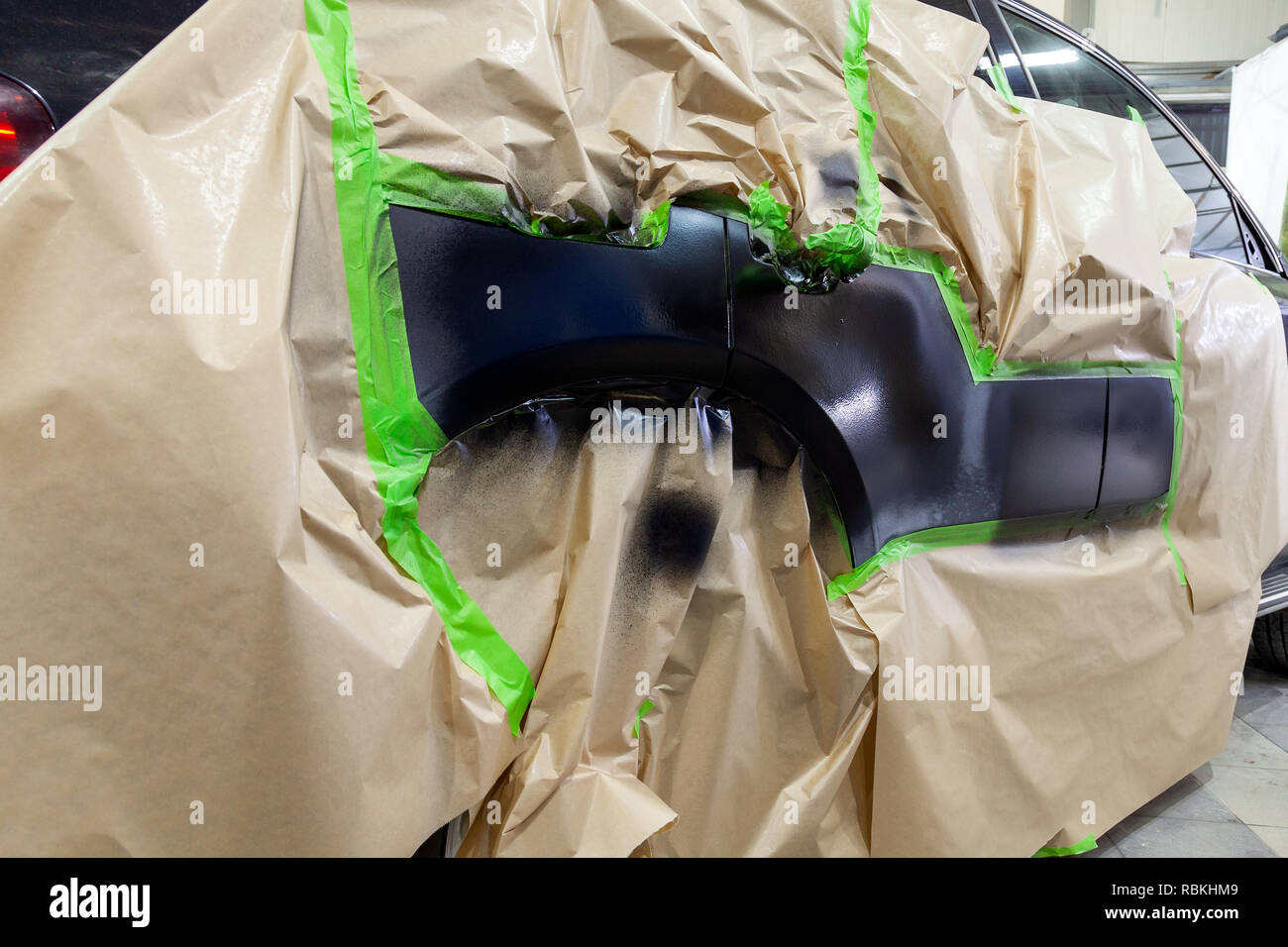 Partial painting of the side elements of the body of a black SUV car ...