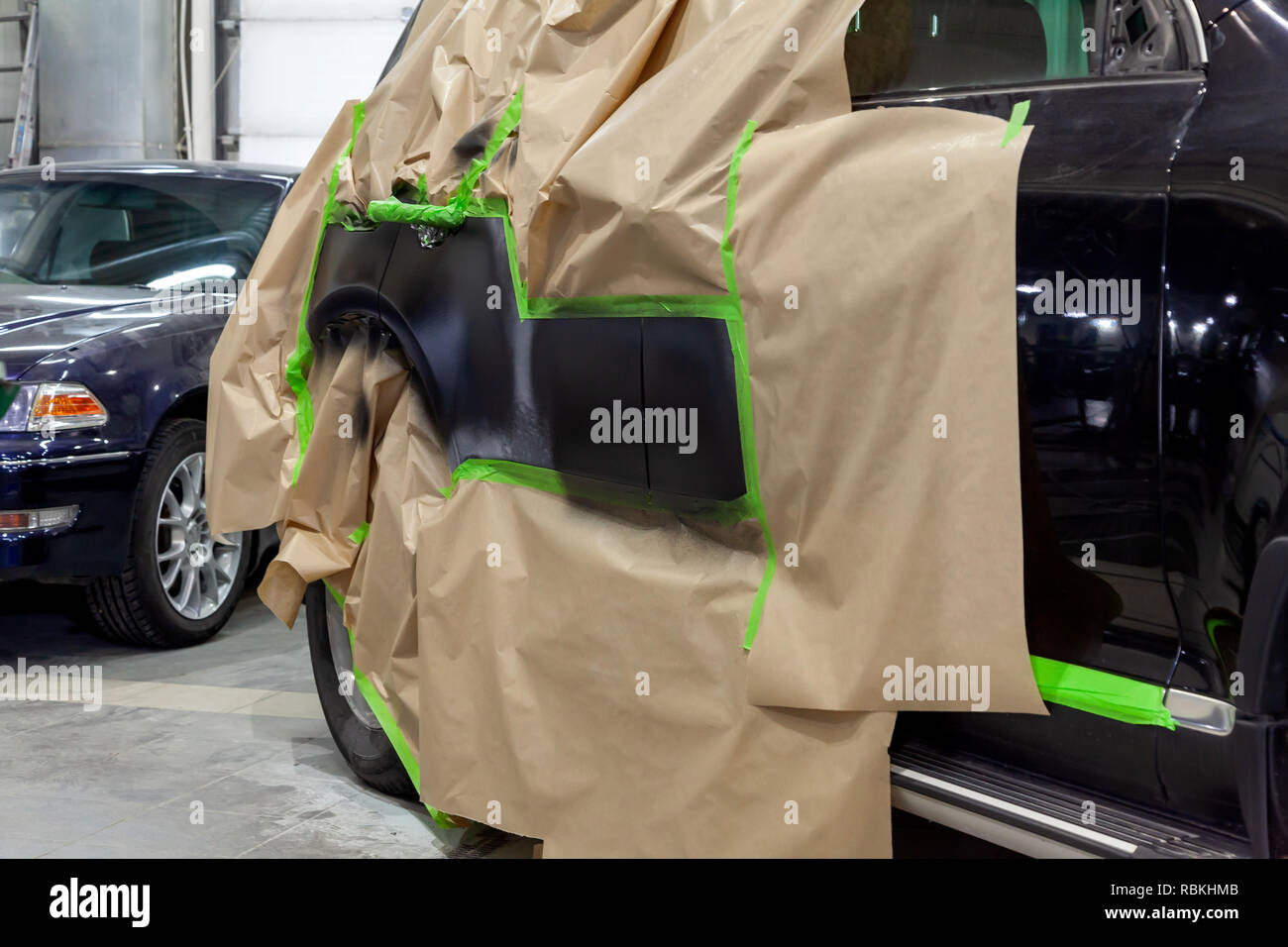 Partial painting of the side elements of the body of a black SUV car ...