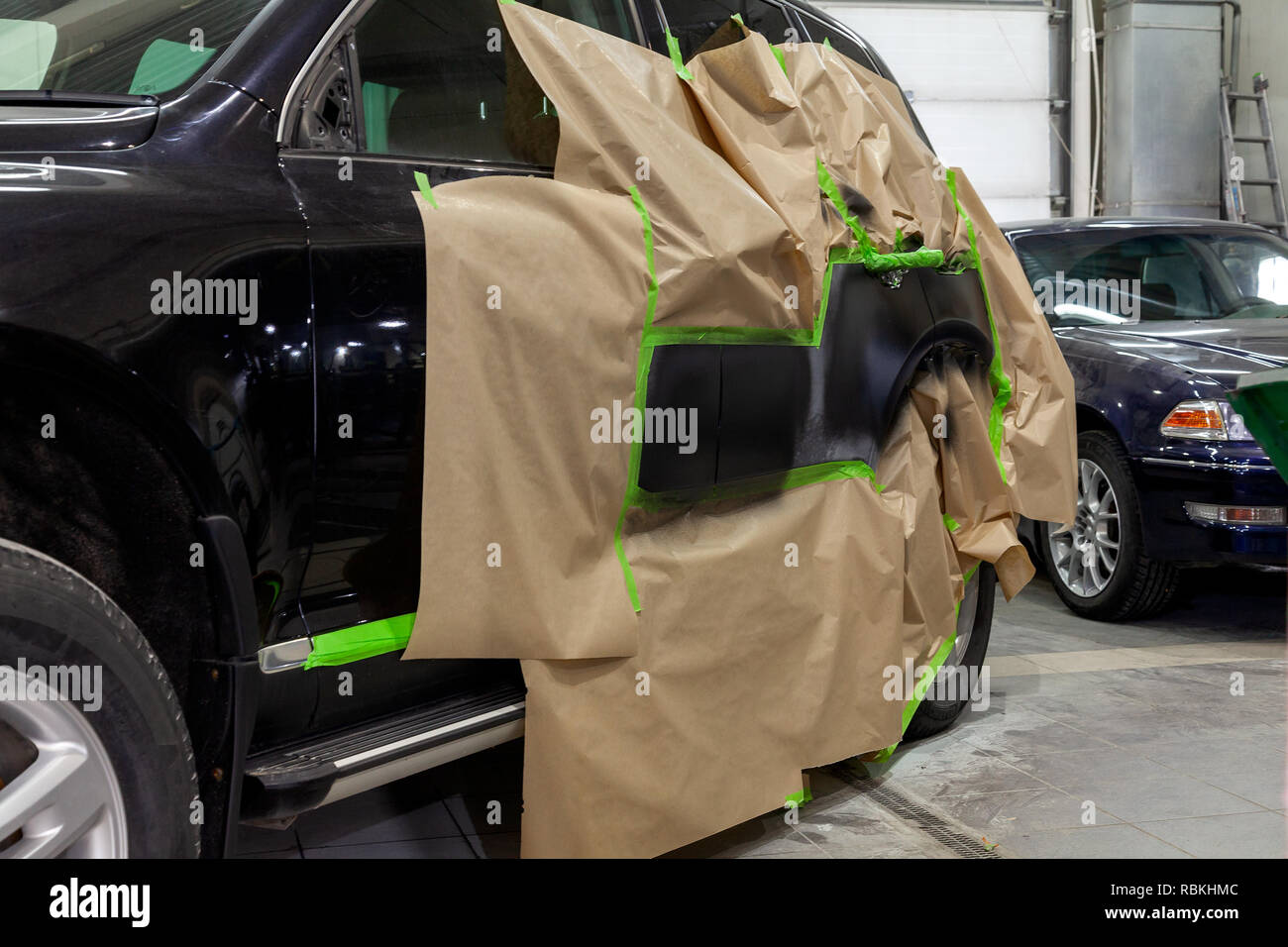 Partial painting of the side elements of the body of a black SUV car ...