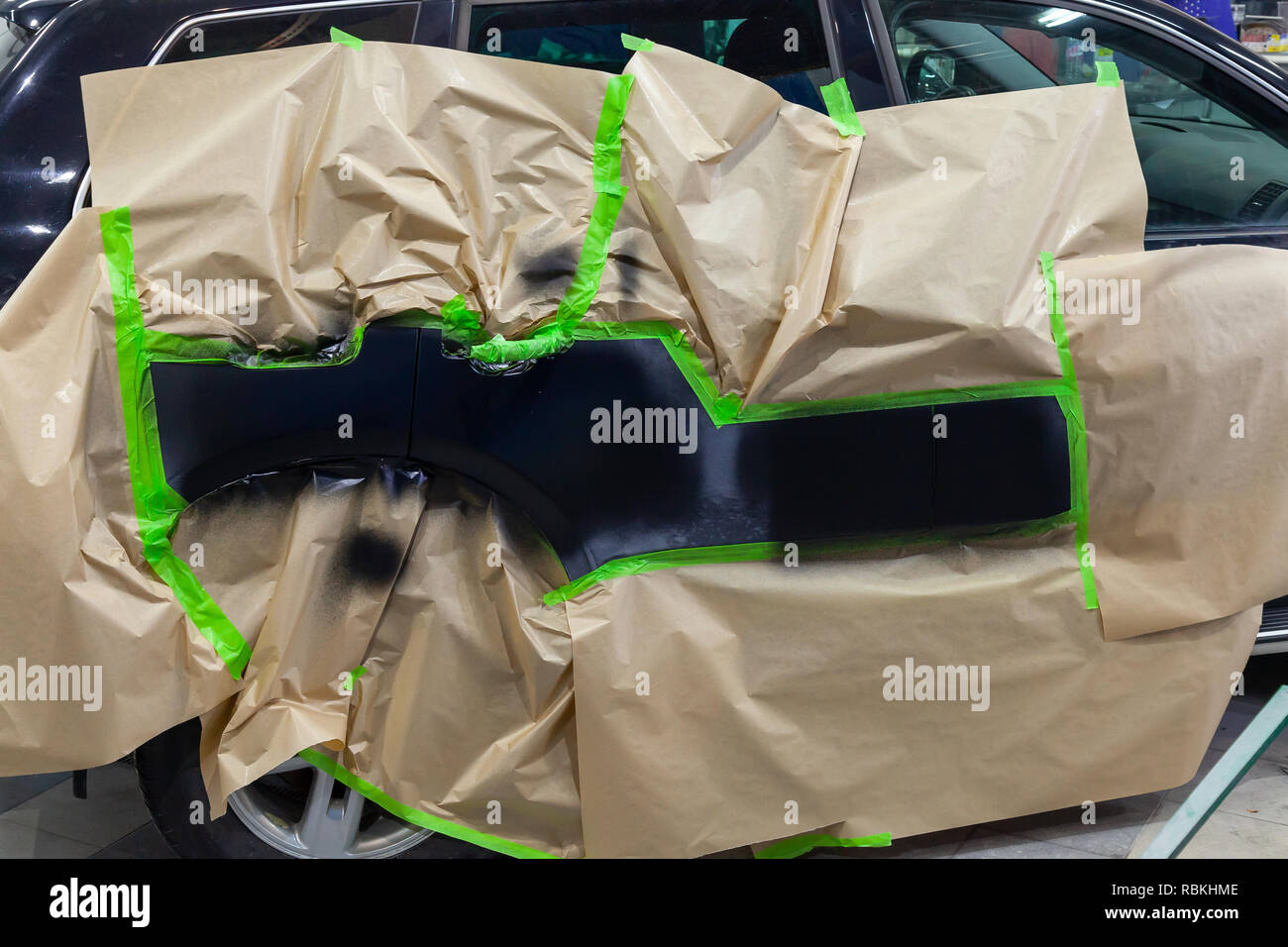 Partial painting of the side elements of the body of a black SUV car ...