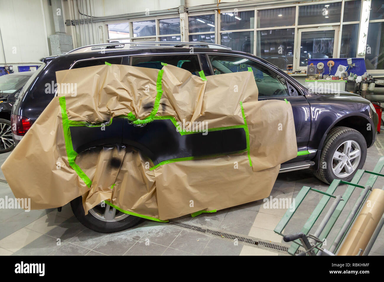 Partial painting of the side elements of the body of a black SUV car ...