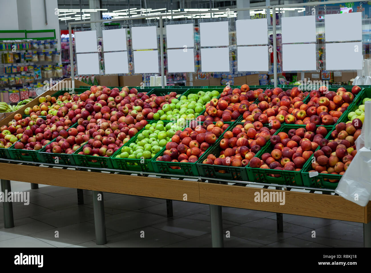 A large rack with baskets with different types of apples in the fruit ...