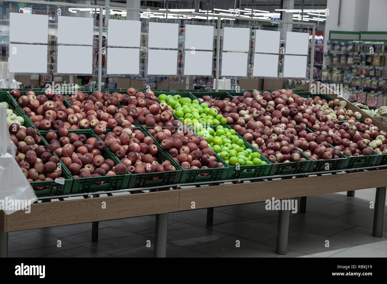 A large rack with baskets with different types of apples in the fruit ...