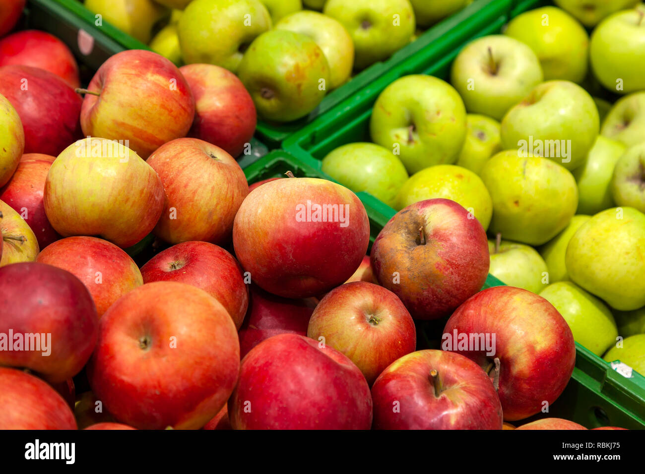 Close-up large, selective, colorful green and red apples on the counter ...