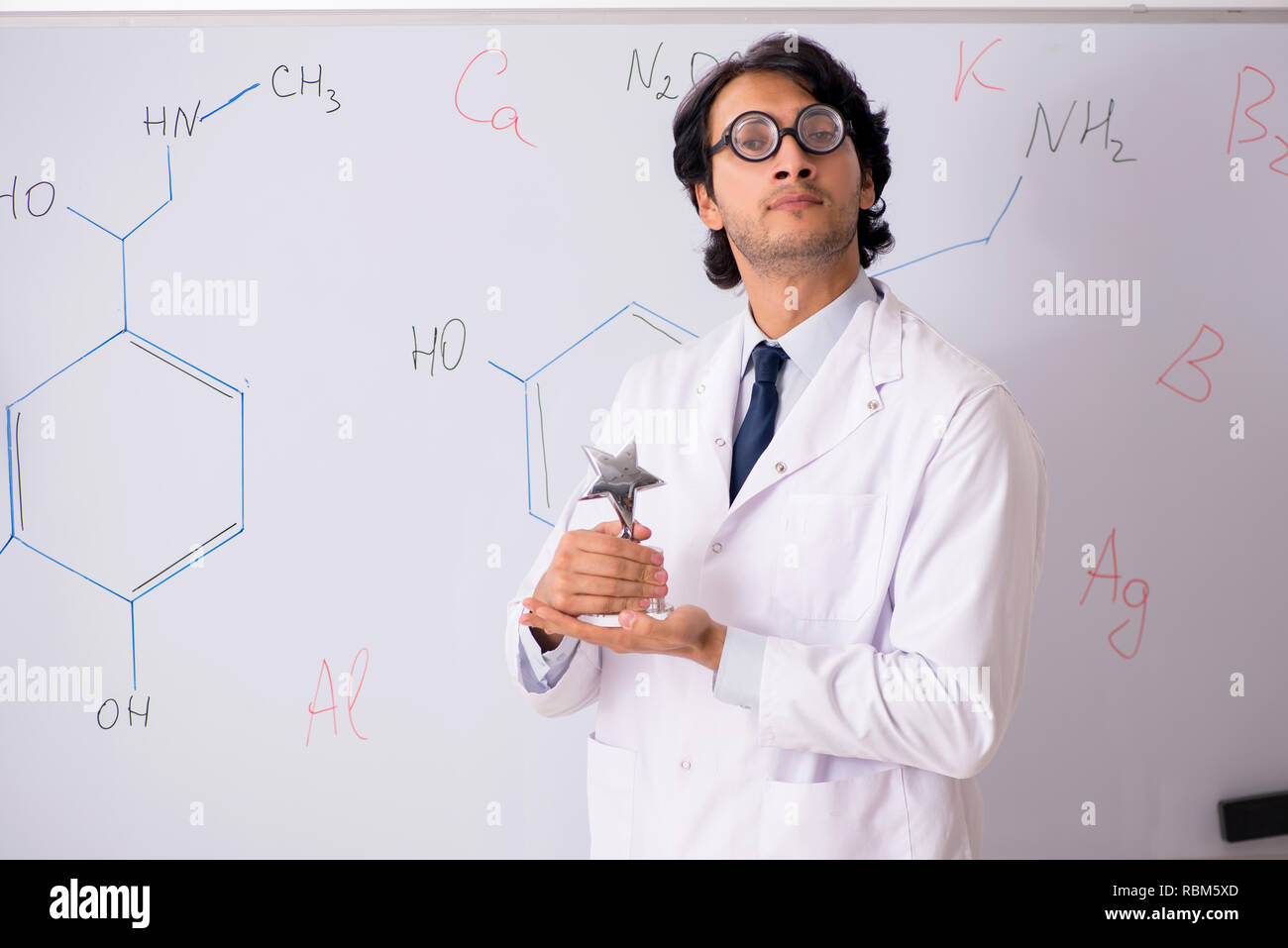 Young funny chemist in front of white board Stock Photo - Alamy