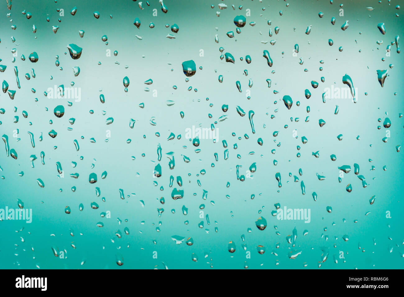 Rain drops on the window, blurred turquoise pool water in the ...