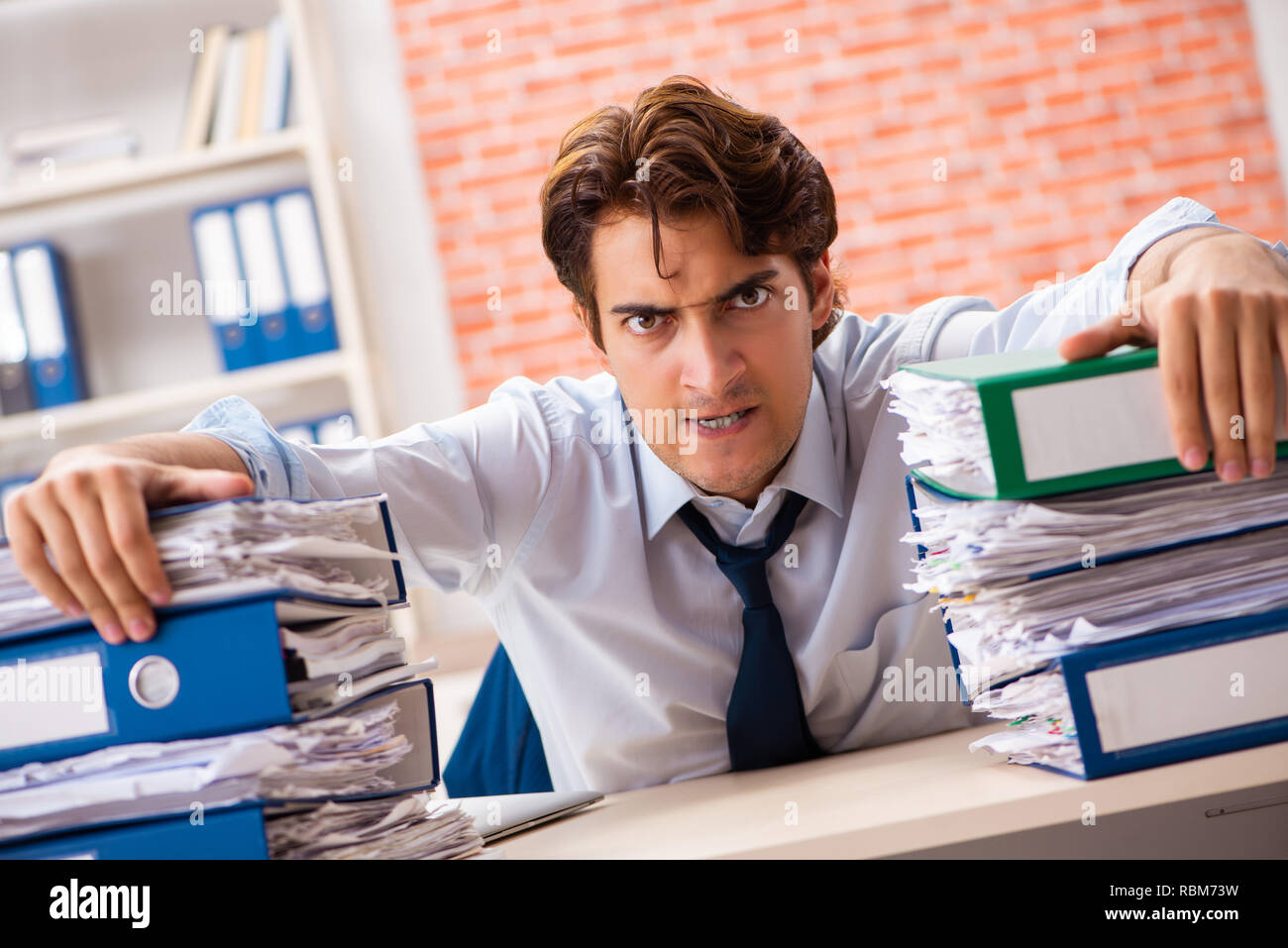 Young elegant man unhappy with too much work Stock Photo - Alamy