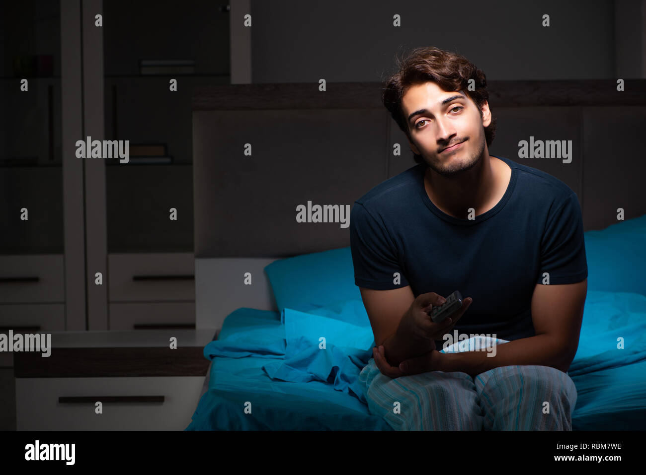 Man watching tv at night in bed Stock Photo - Alamy