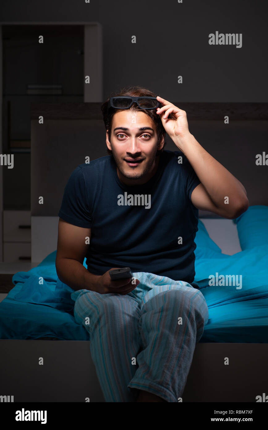 Man watching tv at night in bed Stock Photo - Alamy