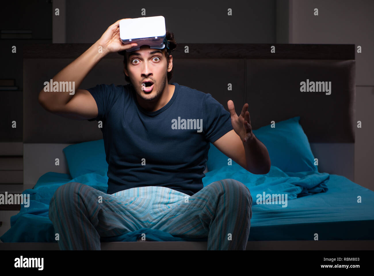 Young man playing computer games at night in bed Stock Photo - Alamy