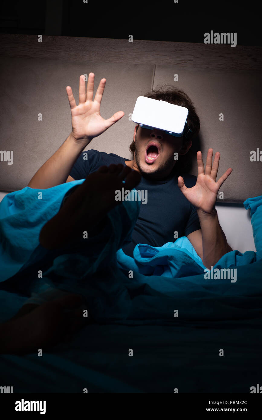 Young man playing computer games at night in bed Stock Photo - Alamy