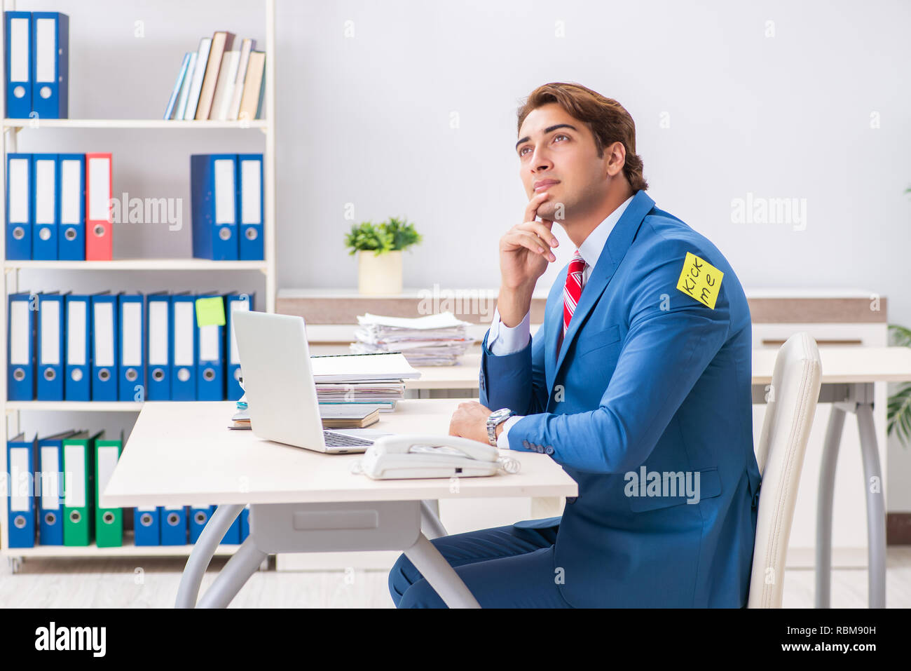 Office prank with kick me message on sticky note Stock Photo - Alamy
