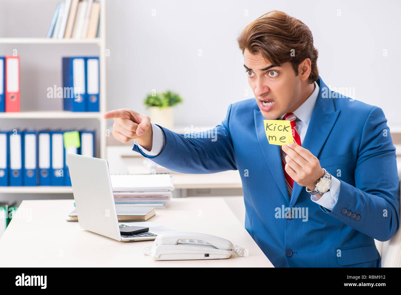Office prank with kick me message on sticky note Stock Photo - Alamy