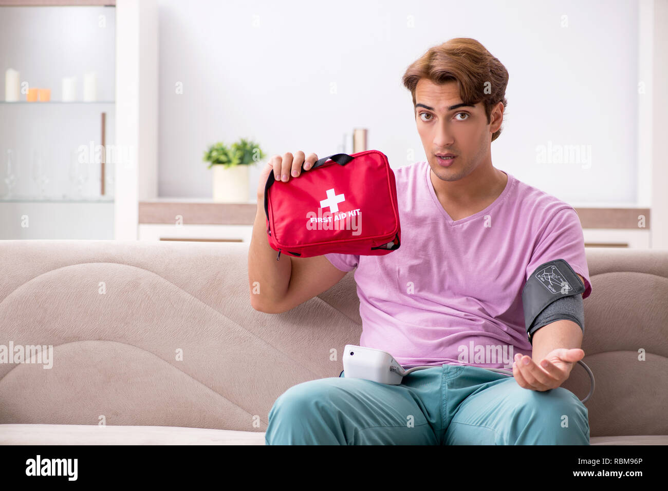 Sick man at home with first aid kit Stock Photo - Alamy