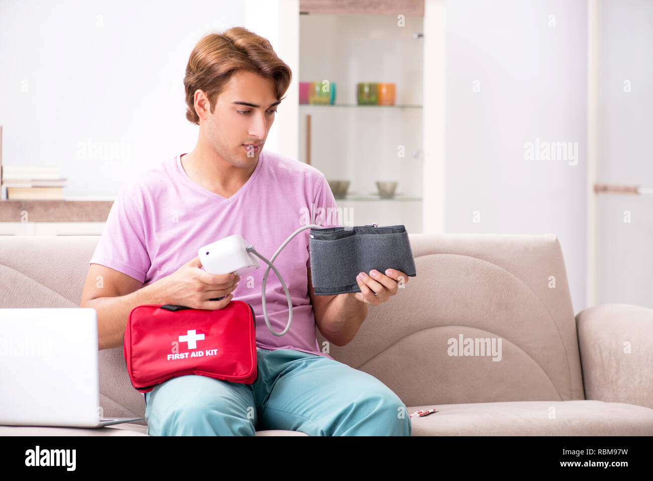 Sick man at home with first aid kit Stock Photo - Alamy