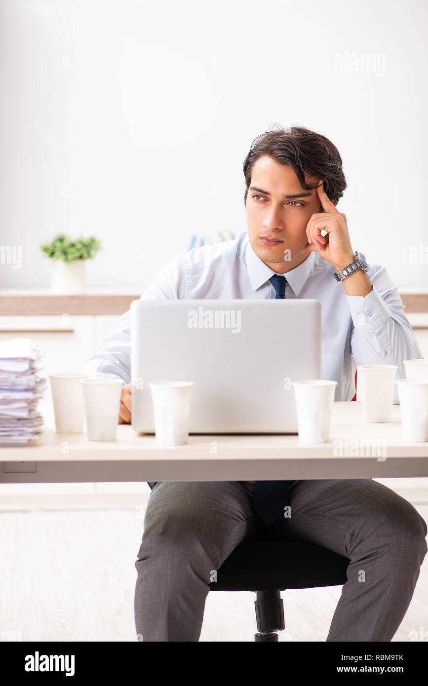 Young employee addicted to coffee Stock Photo - Alamy