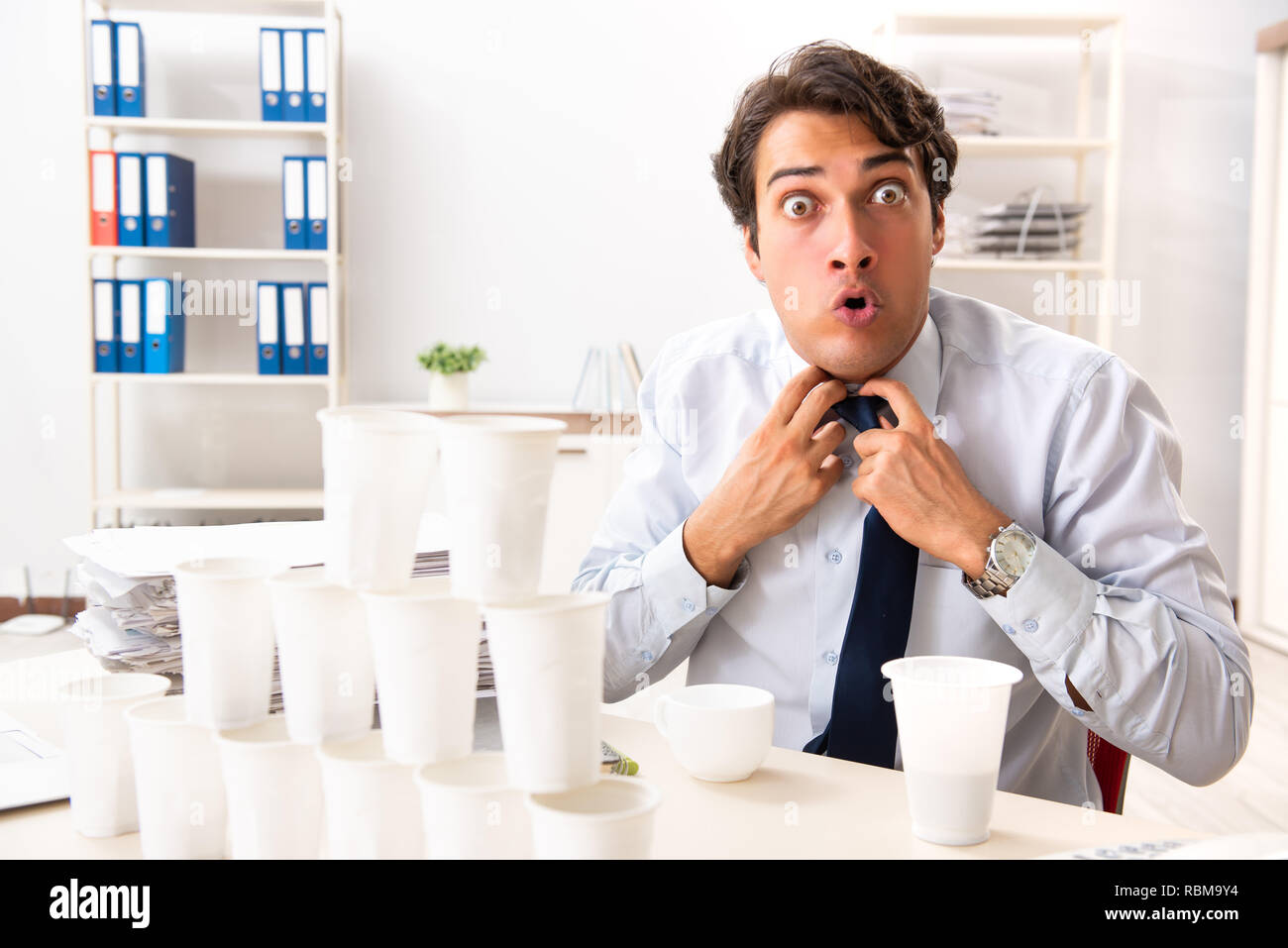 Young employee building pyramid from plastic cups Stock Photo - Alamy