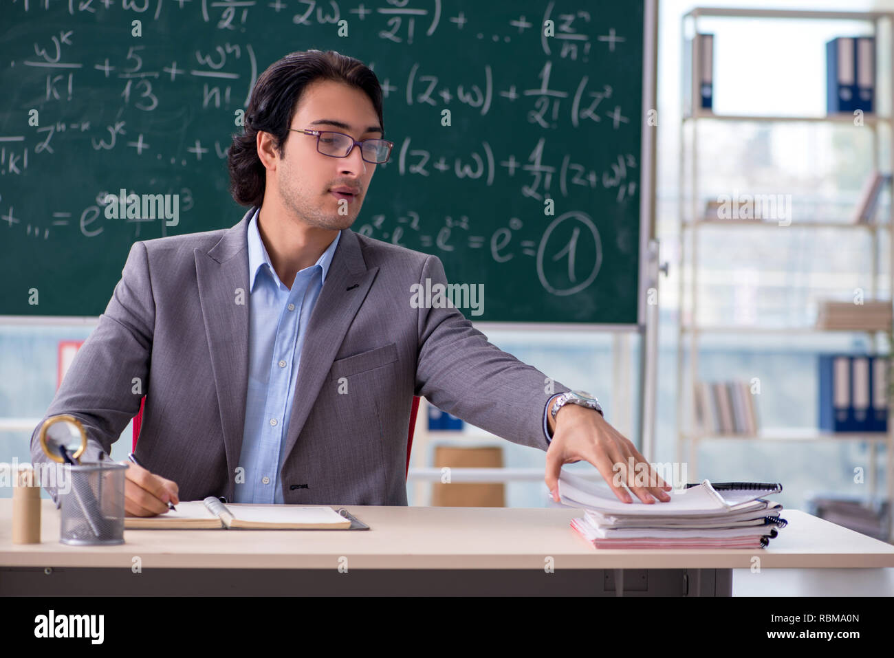 Young handsome math teacher in classroom Stock Photo - Alamy