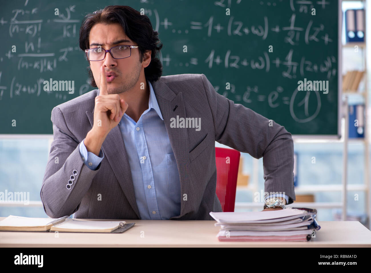 Young handsome math teacher in classroom Stock Photo - Alamy