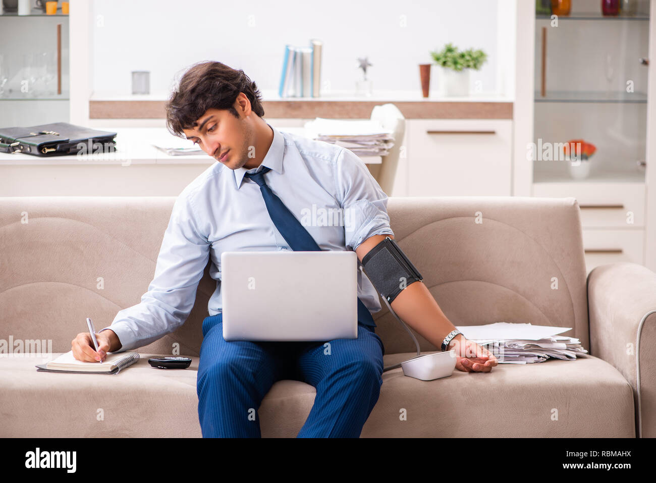 Man under stress measuring his blood pressure Stock Photo - Alamy