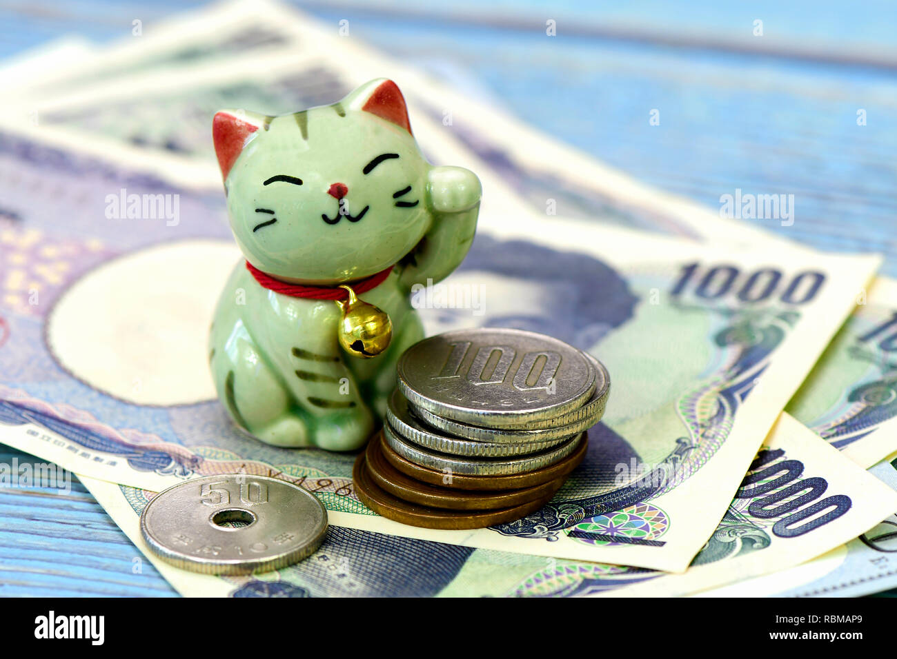 Maneki-neko, the lucky cat and Japanese money Stock Photo - Alamy