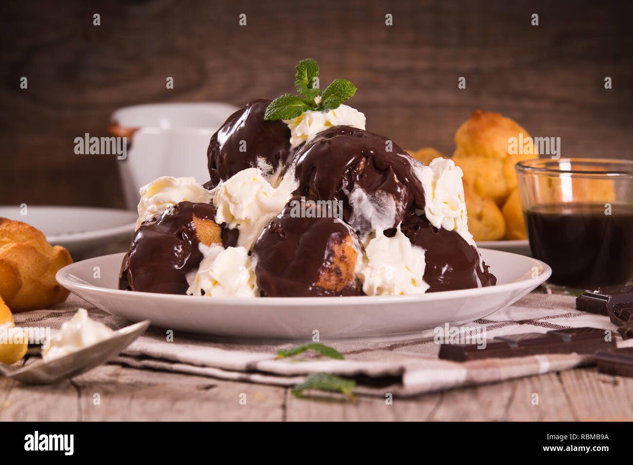 Chocolate profiteroles with chantilly cream hi-res stock photography ...