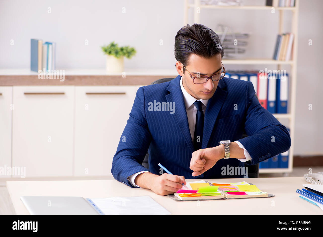 Young handsome employee planning his work activity Stock Photo - Alamy