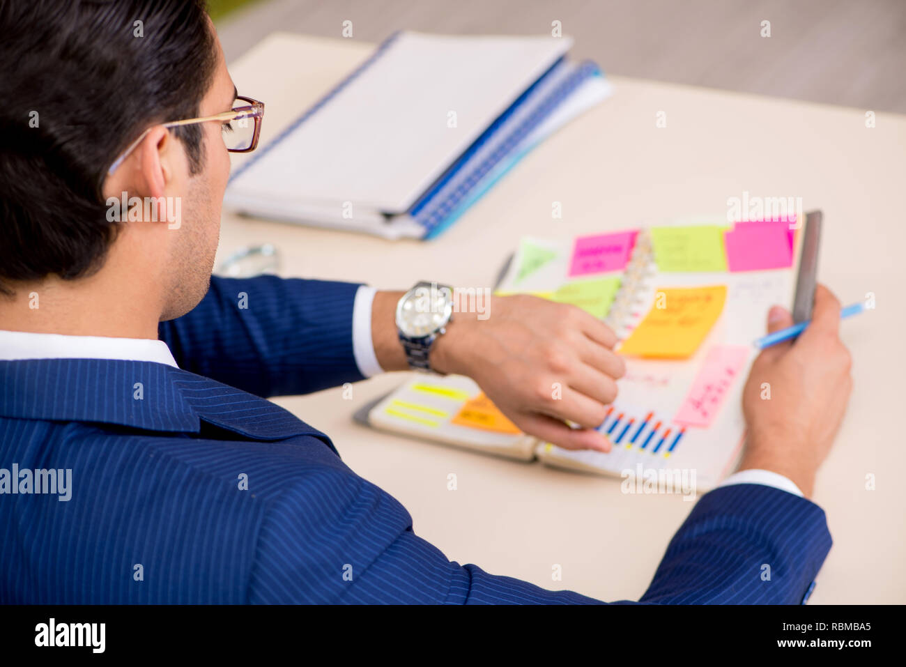 Young handsome employee planning his work activity Stock Photo - Alamy