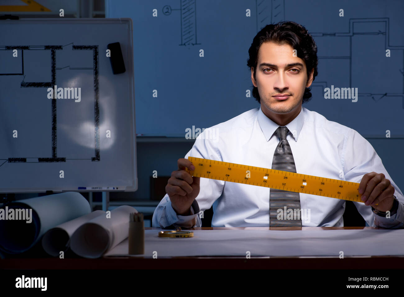 Young construction architect working on project at night Stock Photo ...