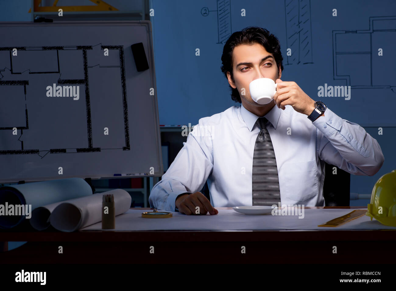 Young construction architect working on project at night Stock Photo ...