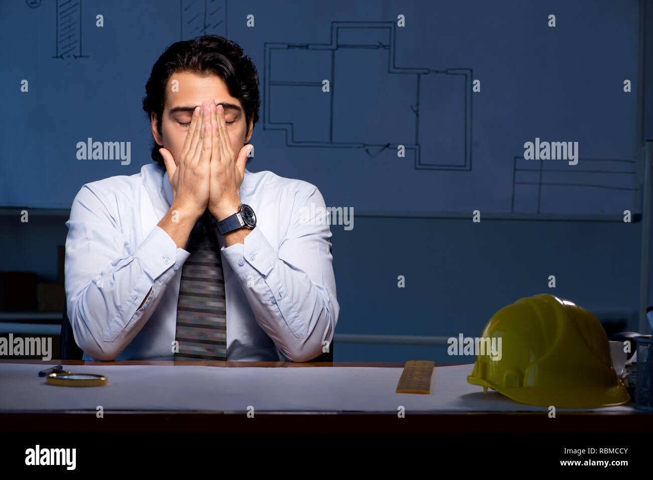 Young construction architect working on project at night Stock Photo ...