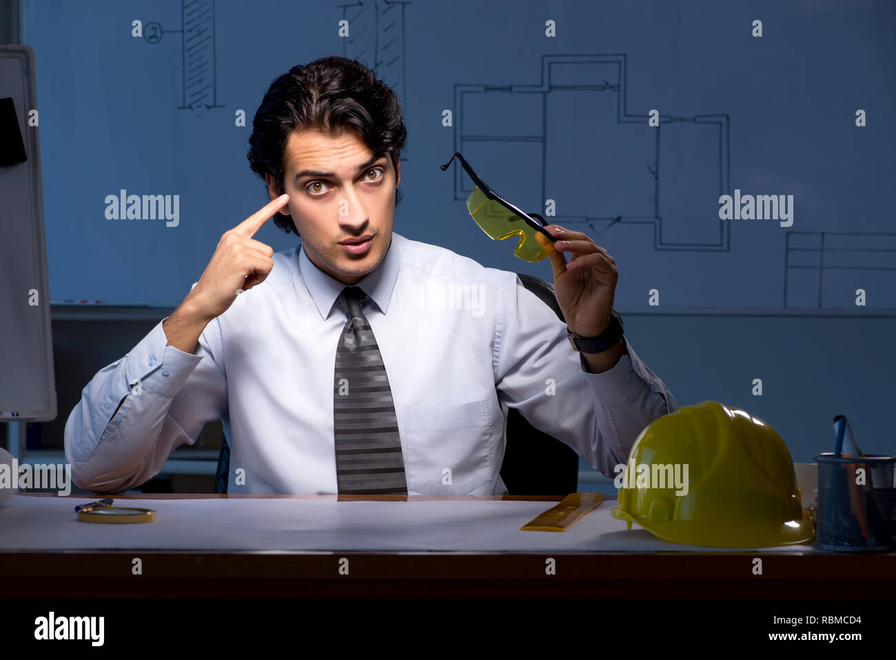 Young construction architect working on project at night Stock Photo ...