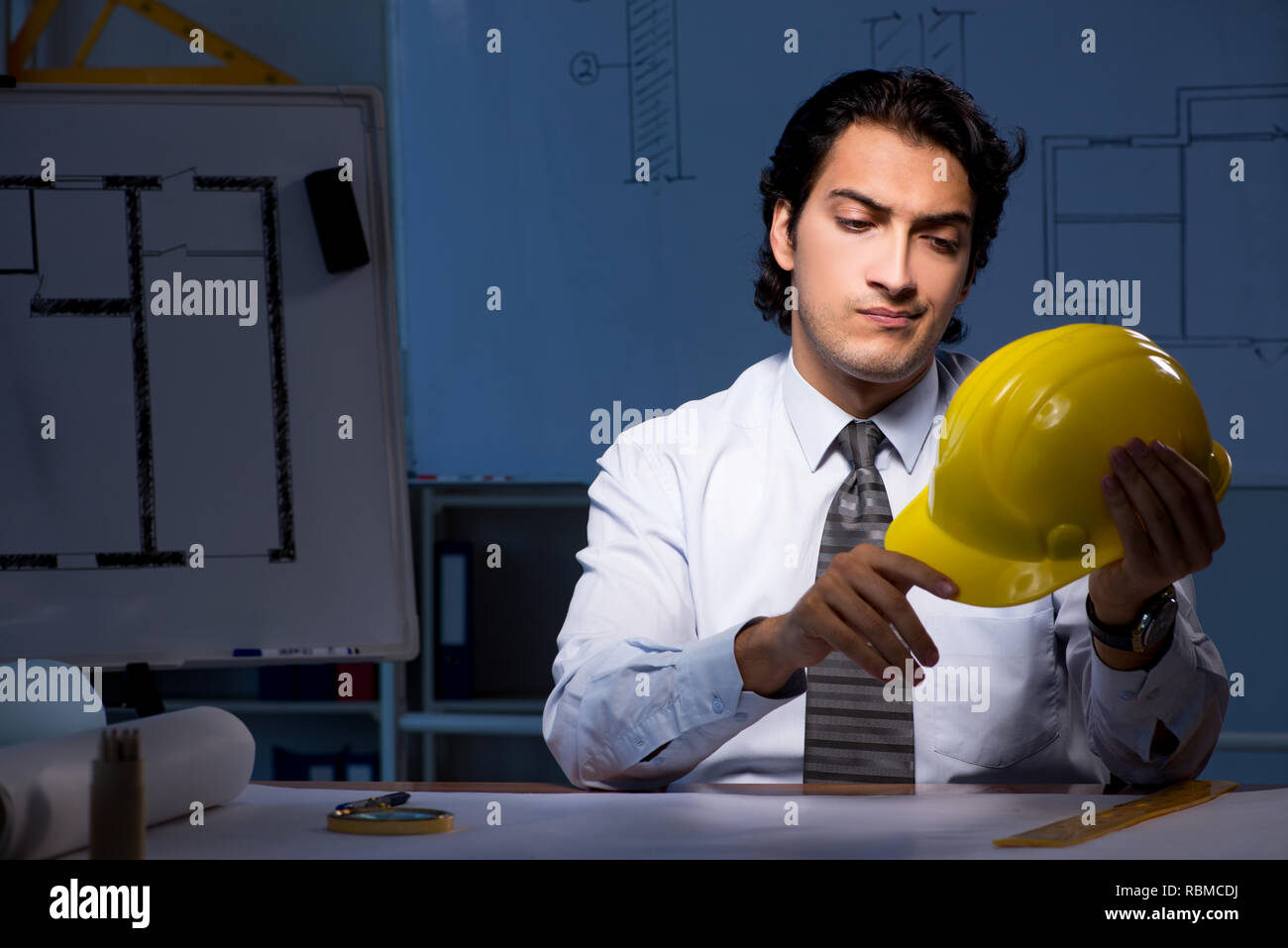 Young construction architect working on project at night Stock Photo ...