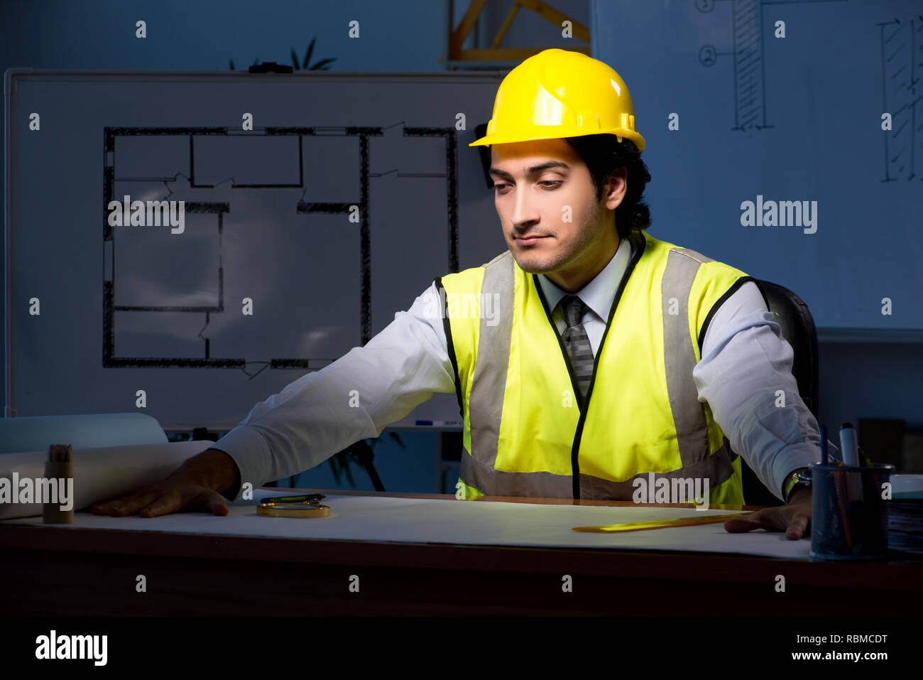 Young construction architect working on project at night Stock Photo ...