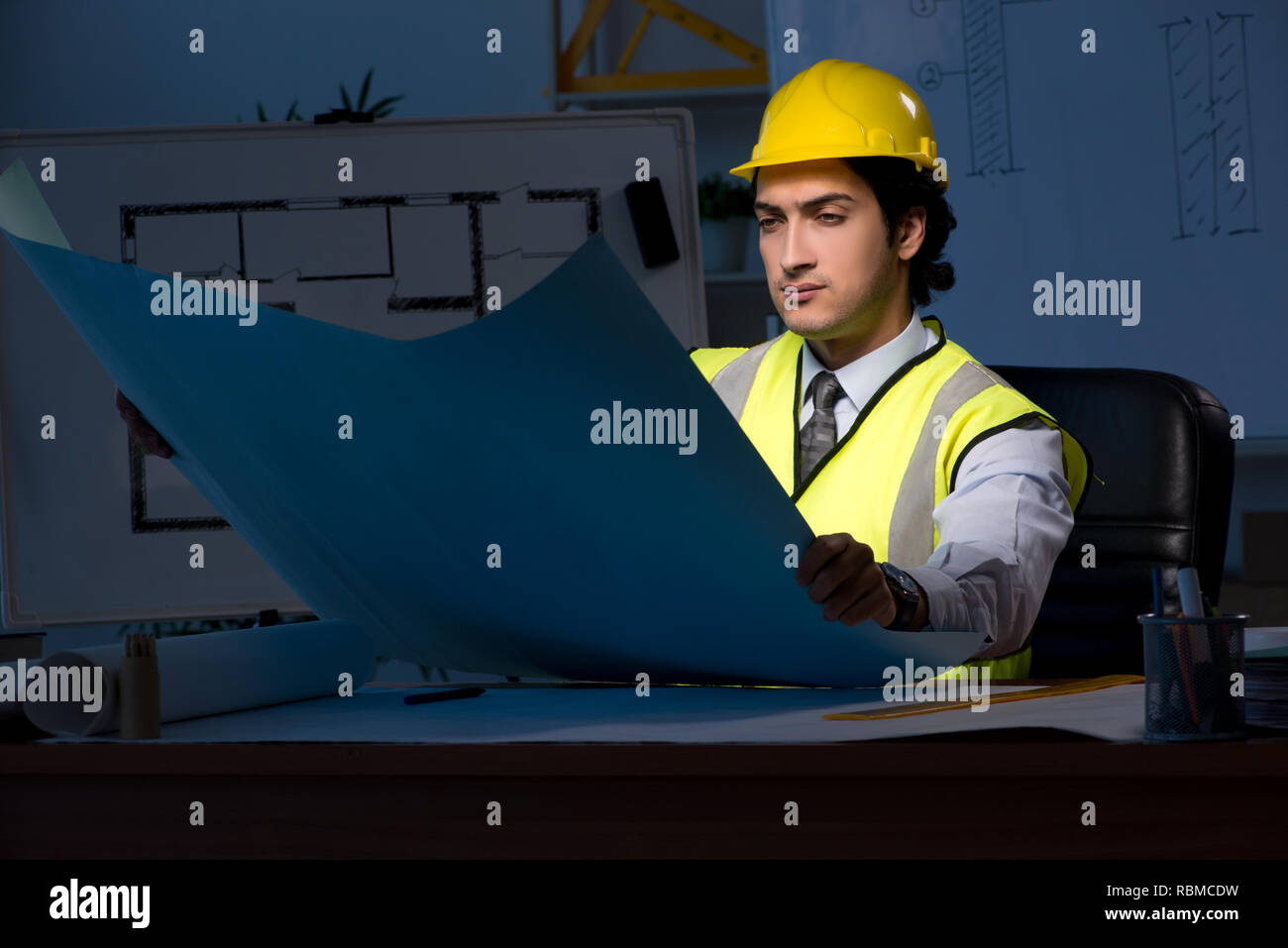 Young construction architect working on project at night Stock Photo ...