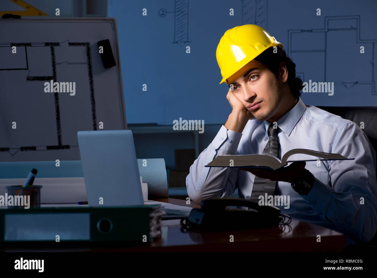 Young construction architect working on project at night Stock Photo ...