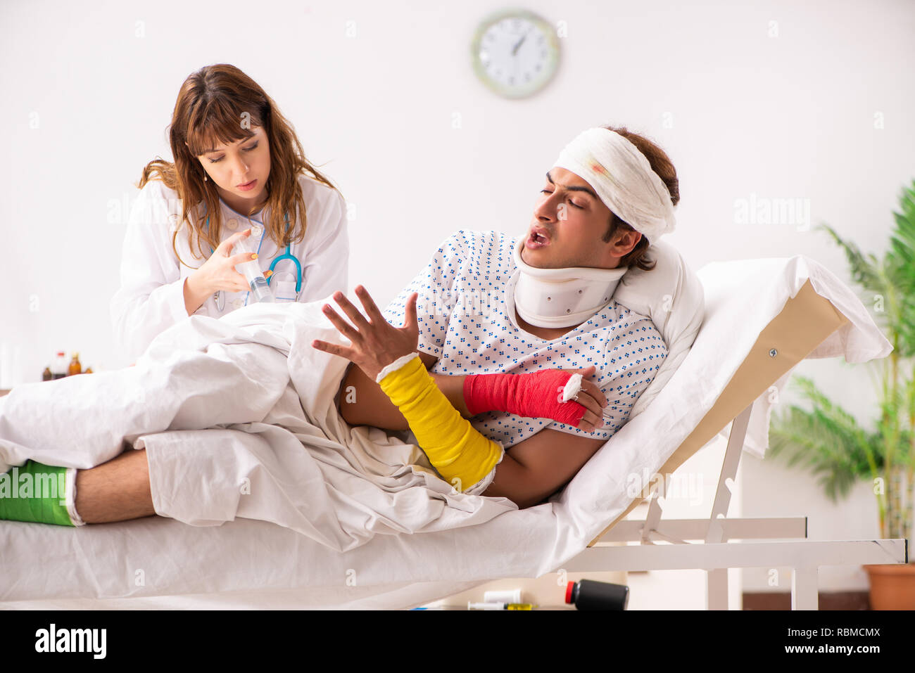 Young doctor examining injured patient Stock Photo - Alamy
