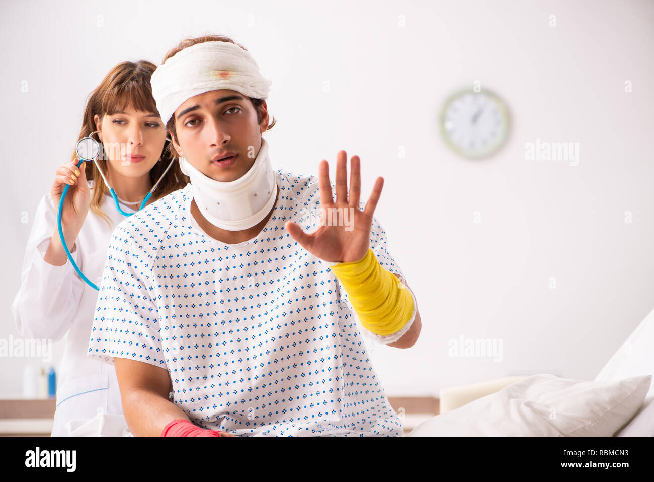 Young doctor examining injured patient Stock Photo - Alamy