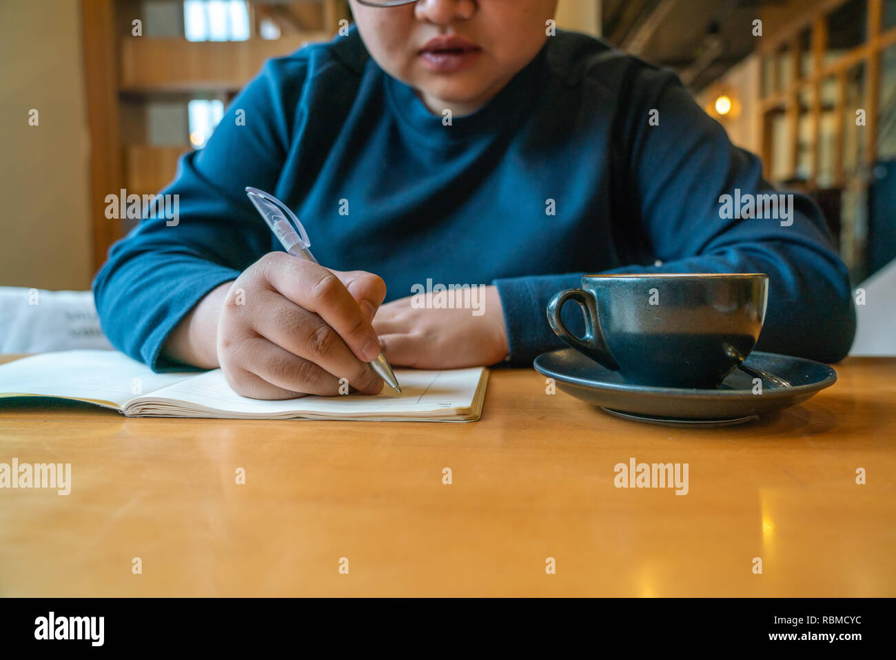 Young girl writing on her notebook Stock Photo - Alamy